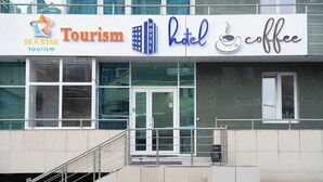 Um edifício com uma placa que diz 'Turismo, Hotel, Café'.