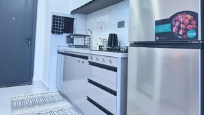 Uma cozinha moderna com geladeira de aço inoxidável, fogão e micro-ondas.