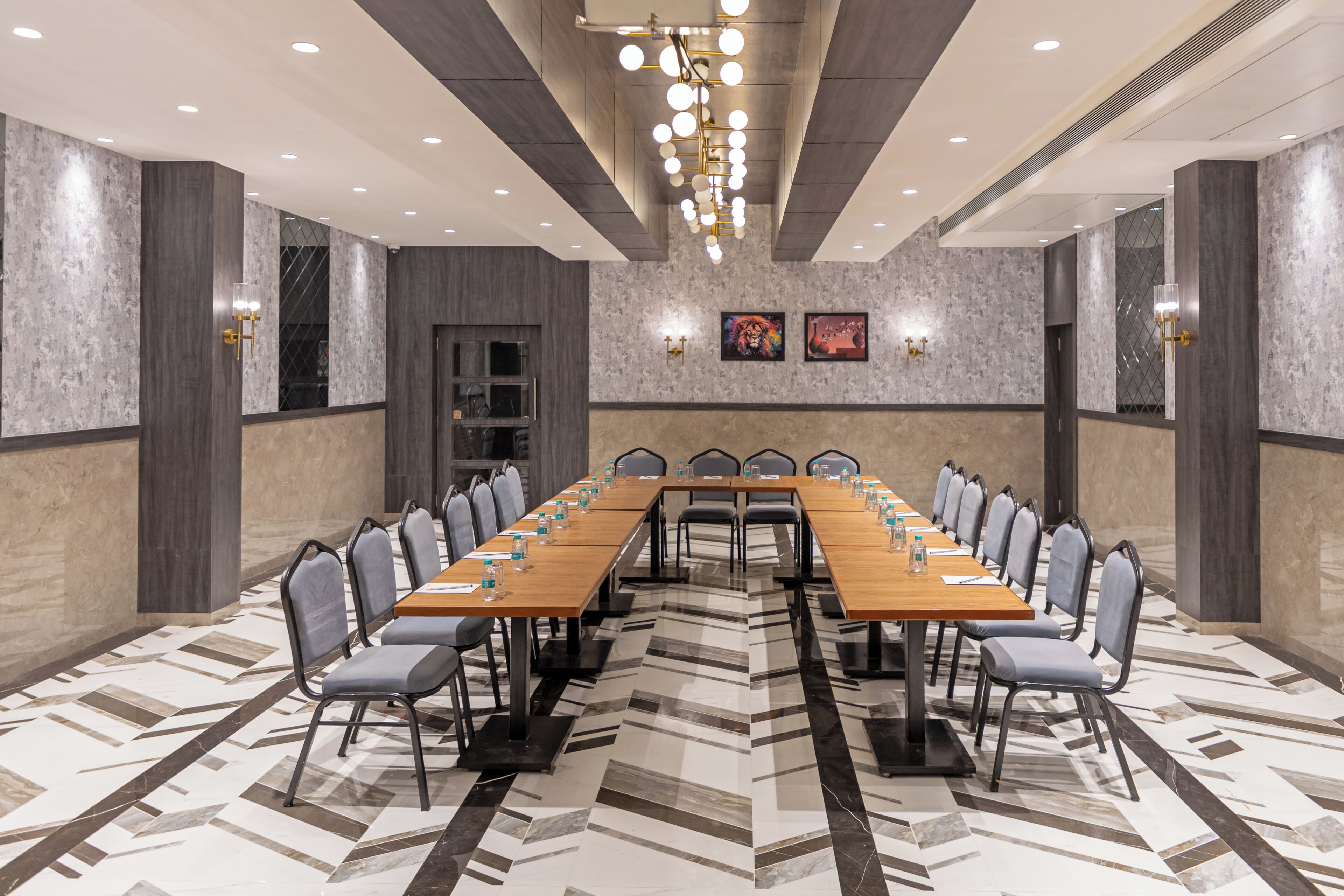 Uma sala de conferências com uma mesa comprida, cadeiras e um piso com padrão.