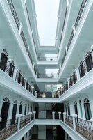 Um edifício com vários níveis, varandas, grades e uma escadaria central.