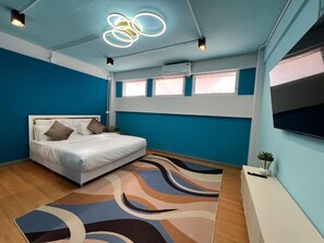 Quarto com uma cama, televisão, janela e luminária no teto.