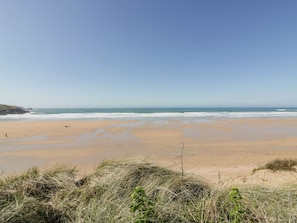 Uma praia com dunas de areia e o oceano.