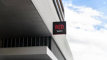 Um edifício com estilo arquitetônico moderno, exibindo uma placa grande com a inscrição 'RED'.