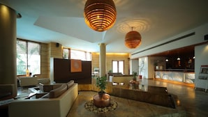 Um hall amplo com móveis modernos, um elemento central de água e um balcão de recepção.