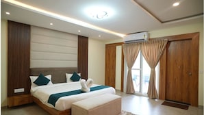 Quarto moderno com uma cama grande, cabeceira de madeira, mesa de cabeceira e janela com cortinas.