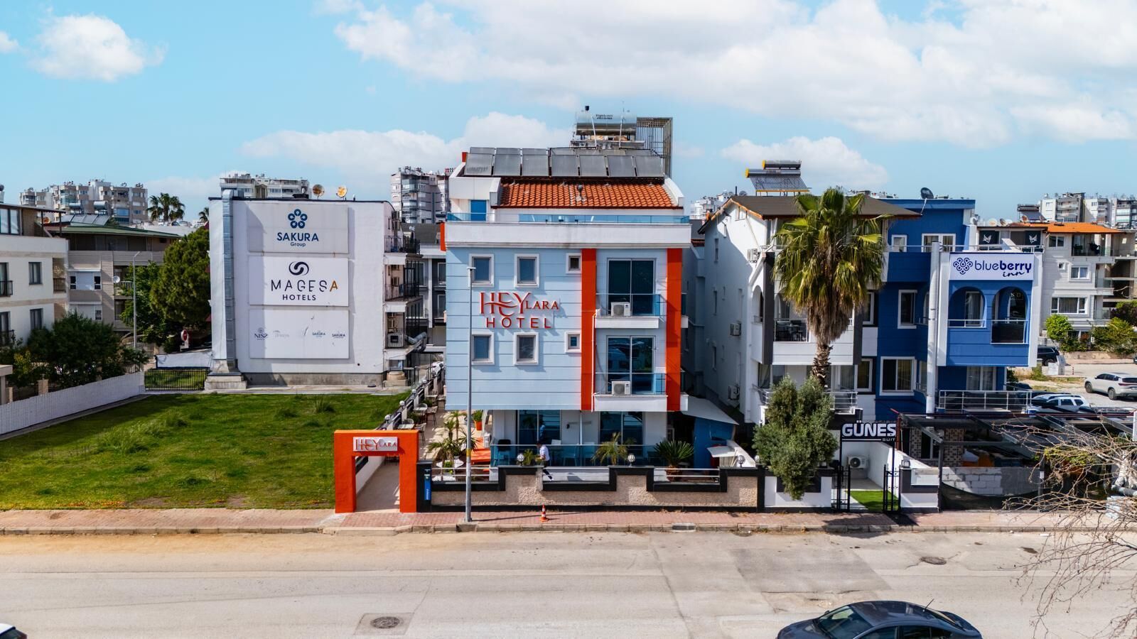 Hotel com fachada moderna, entrada visível e placa indicando o Hotel Heylara.