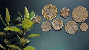 Uma sala de estar com planta em vaso, televisão de tela plana, arte decorativa na parede e um armário.