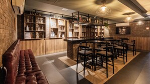 Uma área de bar com bancos, balc ão e prateleiras com garrafas.