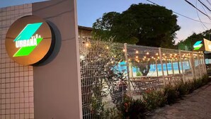 Placa com 'URBANA' e área cercada por luzes de corda.