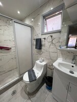 Chuveiro, toalhas de banho, sabonete, shampoo