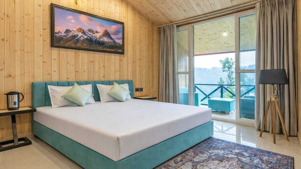 Quarto com cama, um quadro, janela e varanda.