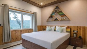 Quarto com cama grande, painéis de madeira, janela com cortinas, mesa de cabeceira com chaleira e prateleira na parede com objetos decorativos.