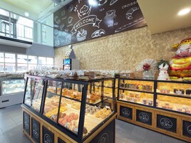 Exposição de doces e pães com uma placa de boas-vindas.