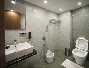 Casa de banho moderna com lavatório, sanita e chuveiro.