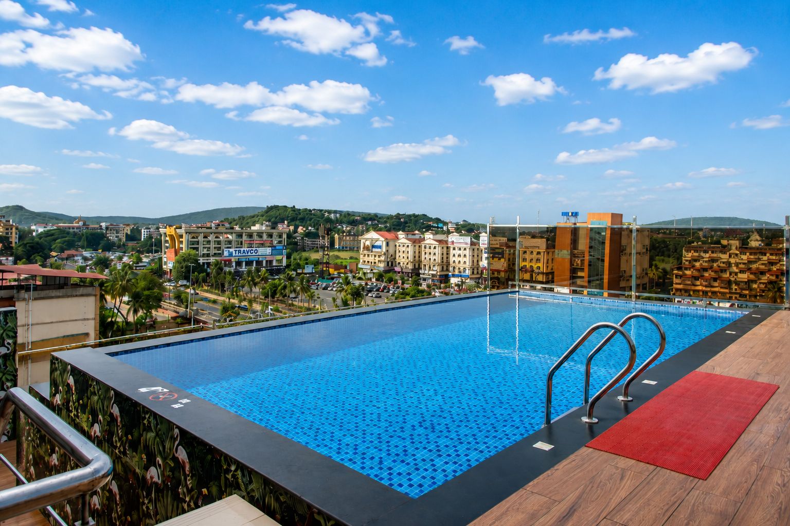 Piscina no terraço com vista para a paisagem urbana e montanhas.