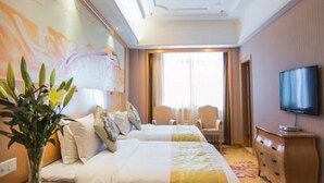 Quarto de hotel com duas camas, televisão, secretária e uma cadeira.