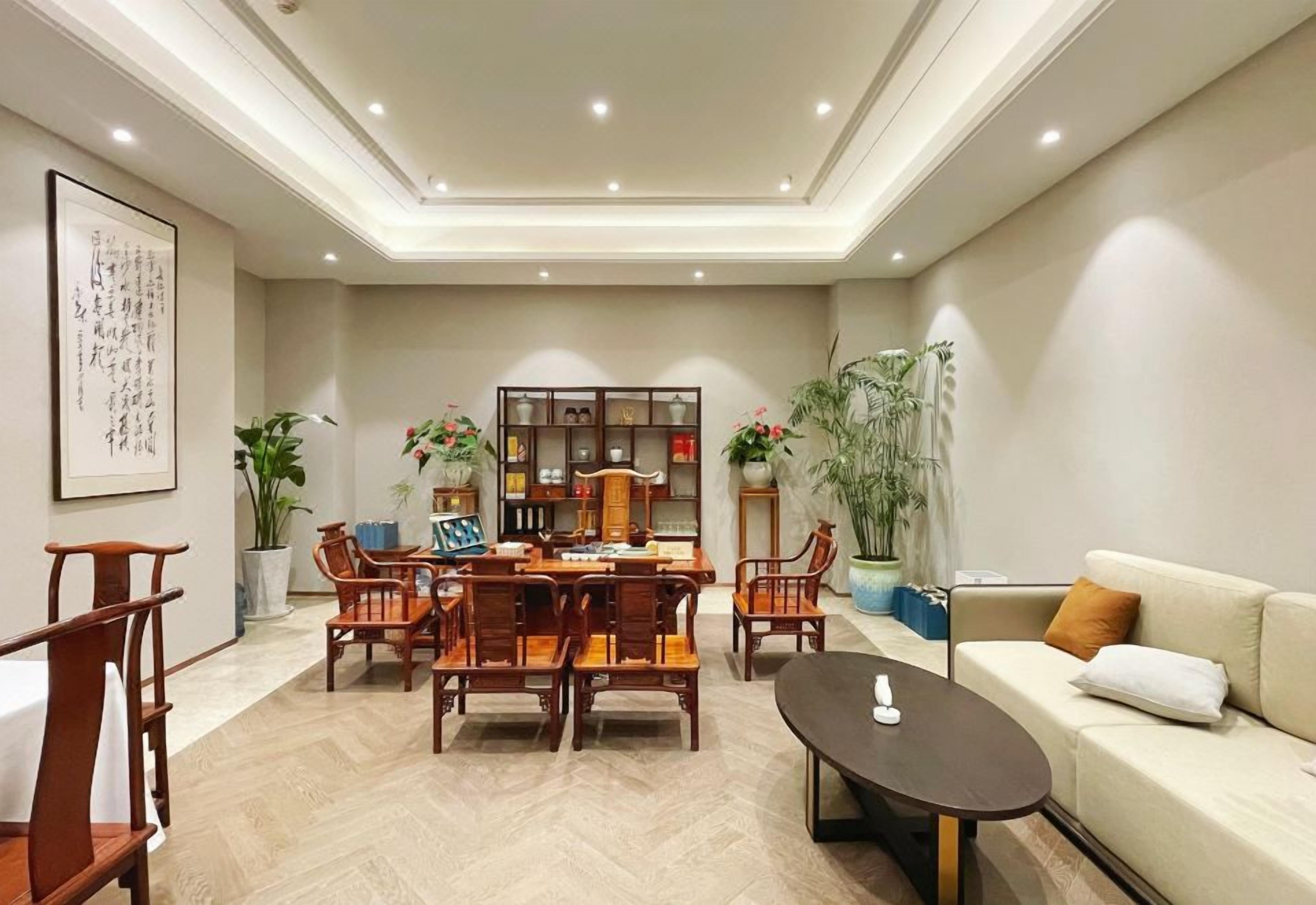 Uma sala de estar moderna com área de jantar, destacando móveis de madeira, um sofá e uma mesa de centro.