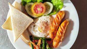 Um prato com ovo frito, torrada, alface, tomate, pepino e salsicha grelhada.