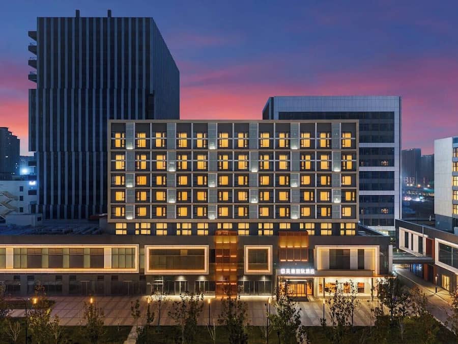 Um hotel moderno com disposição em grade, entrada central e um pátio interno.