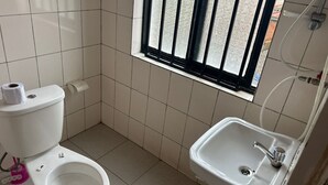 Um banheiro pequeno com vaso sanitário, pia e janela.