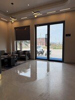 Um interior moderno com área de estar, uma grande porta de vidro que dá para o exterior e teto com iluminação pendente.