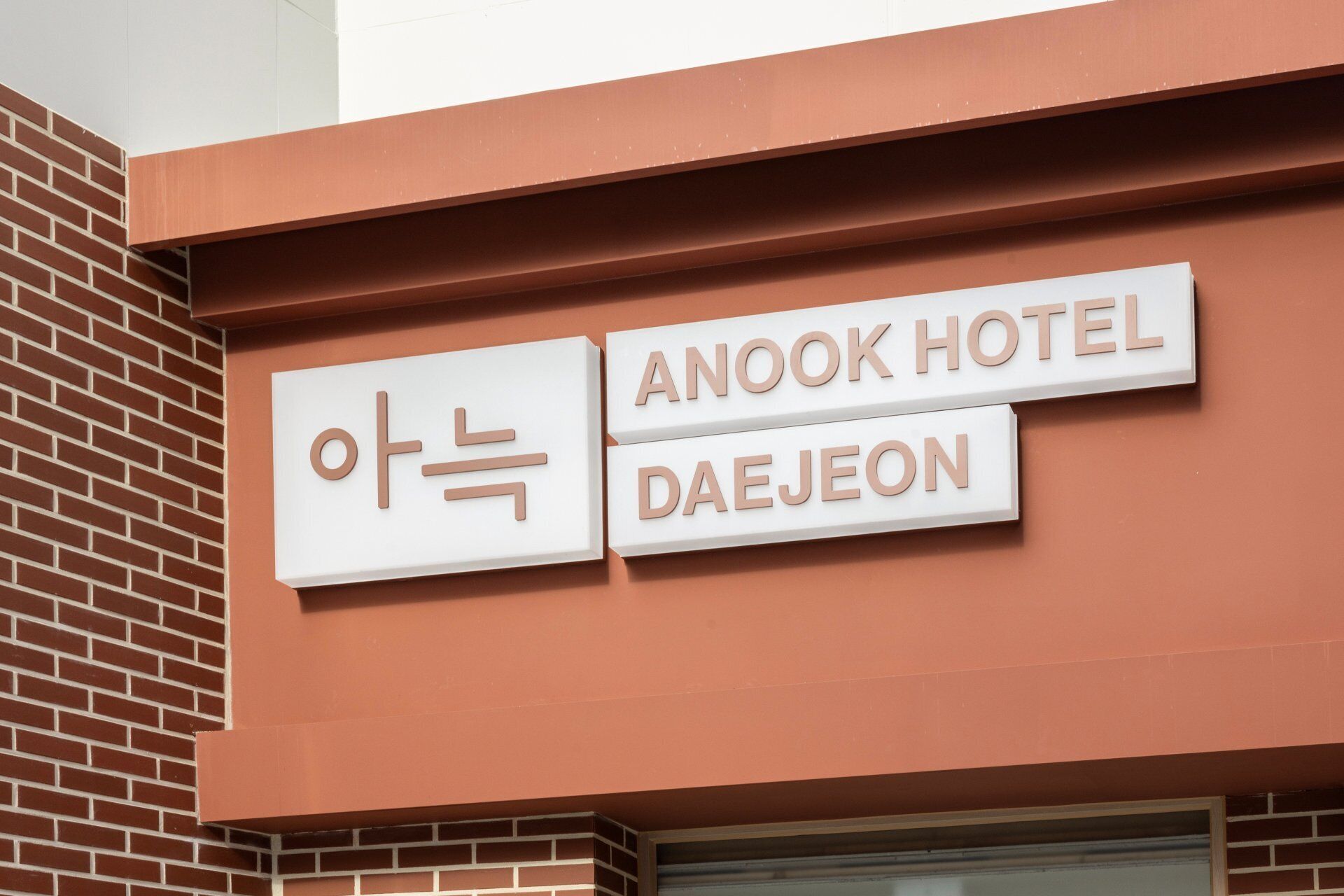 Placa de hotel com o nome 'ANOOK HOTEL' e a localização 'DAEJEON'.