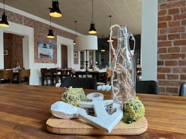 Uma mesa de madeira com objetos decorativos, incluindo uma garrafa de vidro, uma âncora e duas esferas.