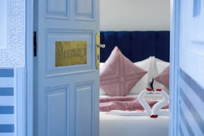 Quarto com cama, decoração de cisne e porta com placa.