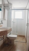 Chuveiro, secador de cabelo, toalhas de banho, papel higiênico
