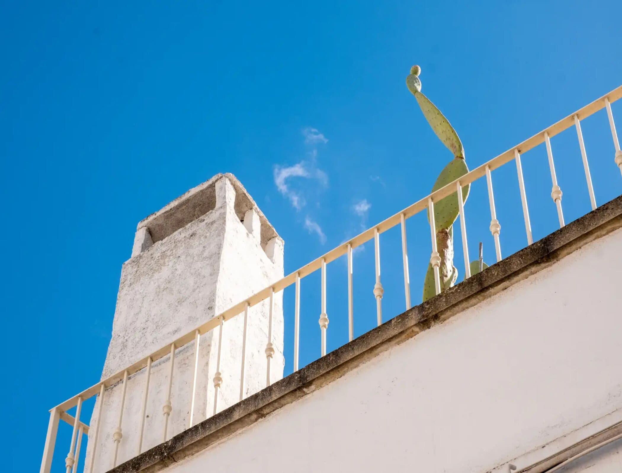Um edifício com fachada branca e guarda-corpo de varanda.