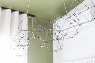 Escultura metálica geométrica suspensa no teto.