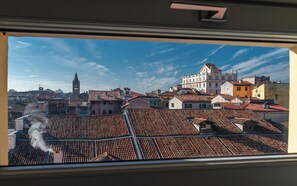 Paisagem urbana com arquitetura tradicional, incluindo uma torre de sino imponente e um edifício grande com cúpula.
