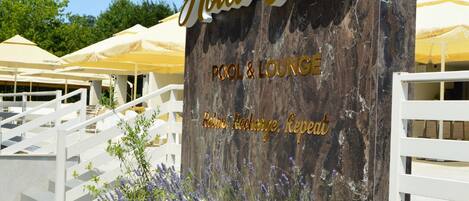 Placa do Hotel Vital com 'PISCINA & LOUNGE' e 'Repetir. Repetir. Repetir'.