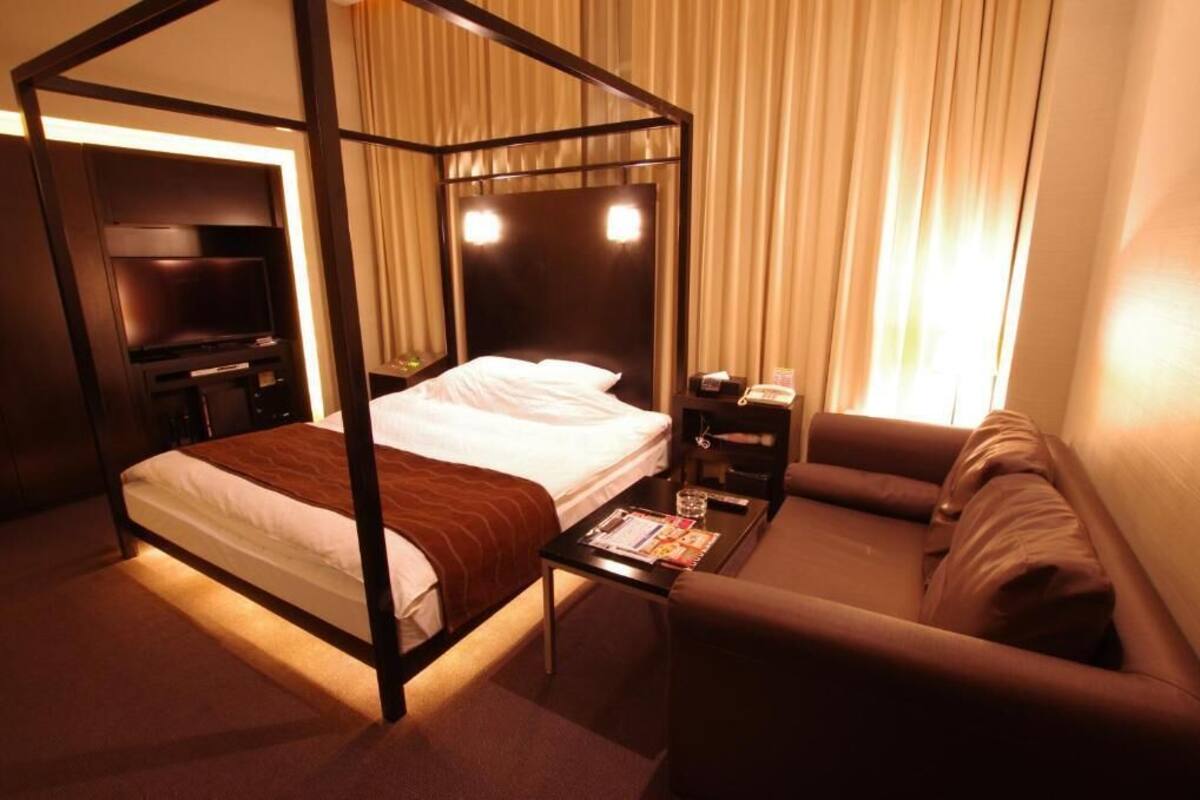 Uma cama de dossel com uma televisão e uma pequena mesa ao lado.