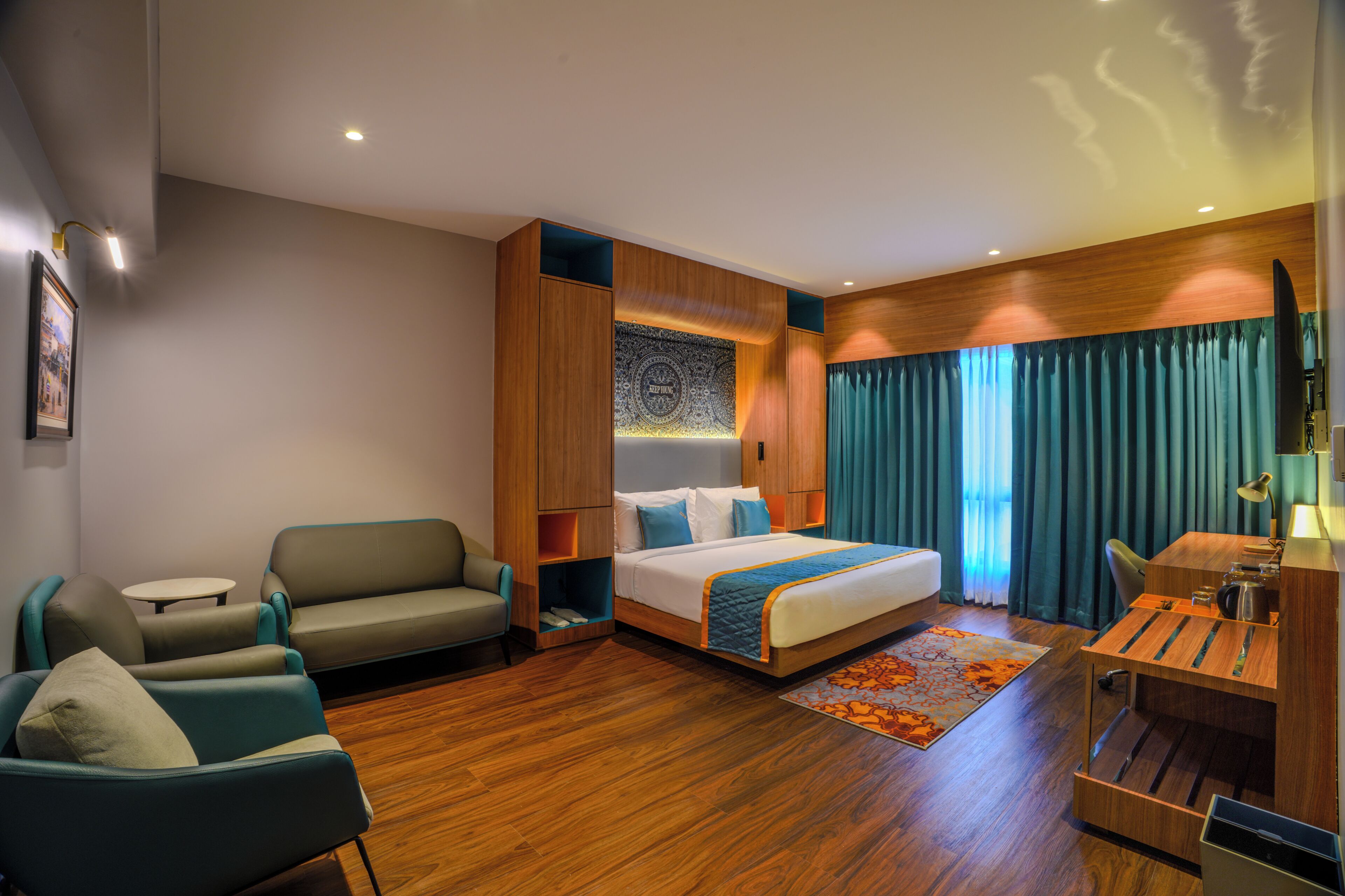 Quarto de hotel com cama, sofá, escrivaninha e uma cadeira.
