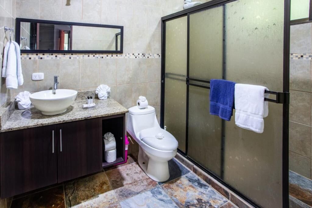 Casa de banho com lavatório, sanita e zona de duche.