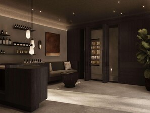 Um interior moderno com área de bar, sofá e uma grande planta em vaso.