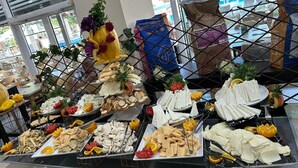 Buffet com diversos alimentos e vista para a janela.