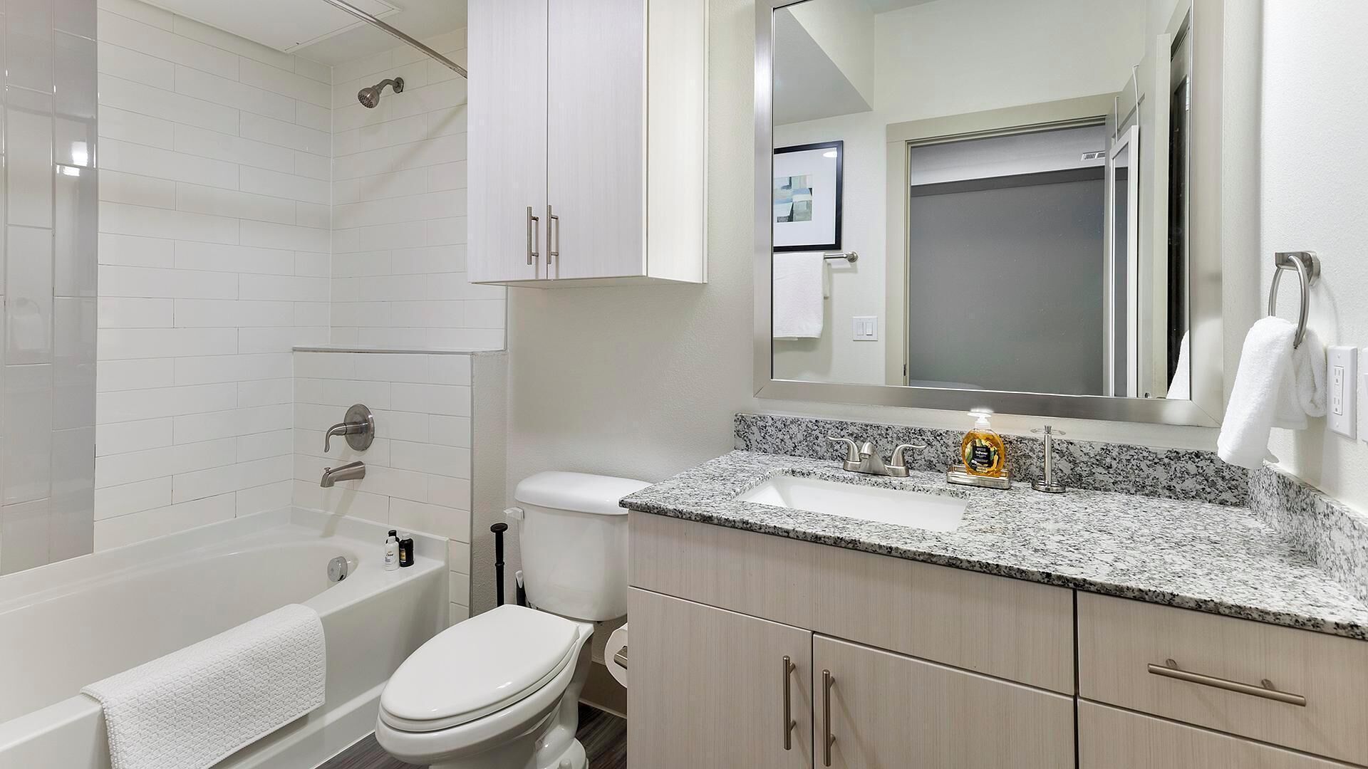 Uma casa de banho moderna com banheira, sanita e lavatório.