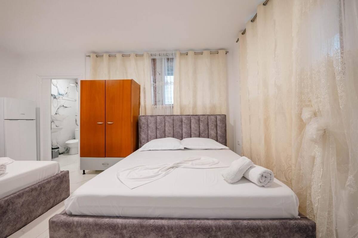 Quarto de hotel com cama, guarda-roupa, banheiro e vista para o exterior.