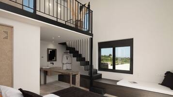 Quarto moderno com cama grande, escrivaninha de madeira, escada e vista para o exterior.