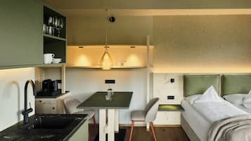 Quarto compacto com cozinha compacta, área de jantar e cama.