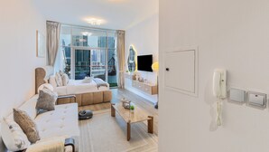 Sala de estar moderna com sofá, mesa de centro e vista para a cidade através de grandes janelas.