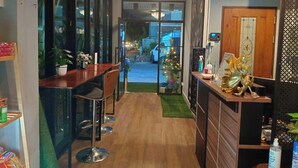 Um saguão de hotel com balcão de recepção, área de bar e um pinheiro de Natal.