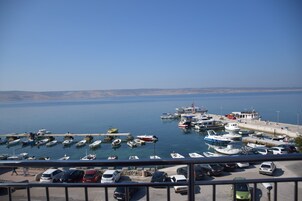Uma marina com barcos atracados, um cais e um estacionamento com carros.