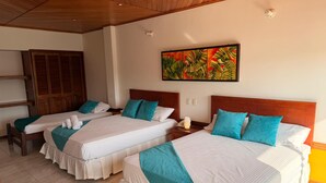 Quarto de hotel com duas camas, um guarda-roupa de madeira, um quadro e chão de azulejos.