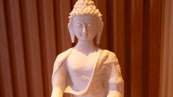 Uma estátua de Buda sentado sobre um pedestal de mármore.