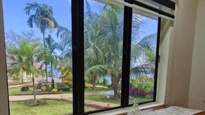 Zona de bar com vista para palmeiras e um jardim.