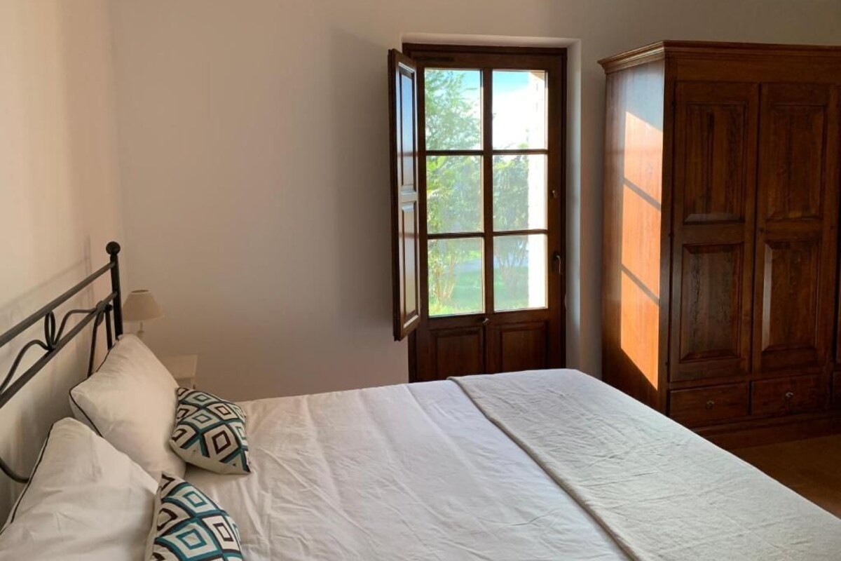 Um quarto com uma cama, uma janela e um guarda-roupa.
