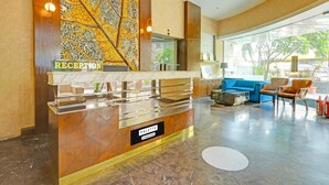 Uma mesa de recepção com uma placa 'RECEPTION', uma placa 'PALETTE' e um grande mural na parede.